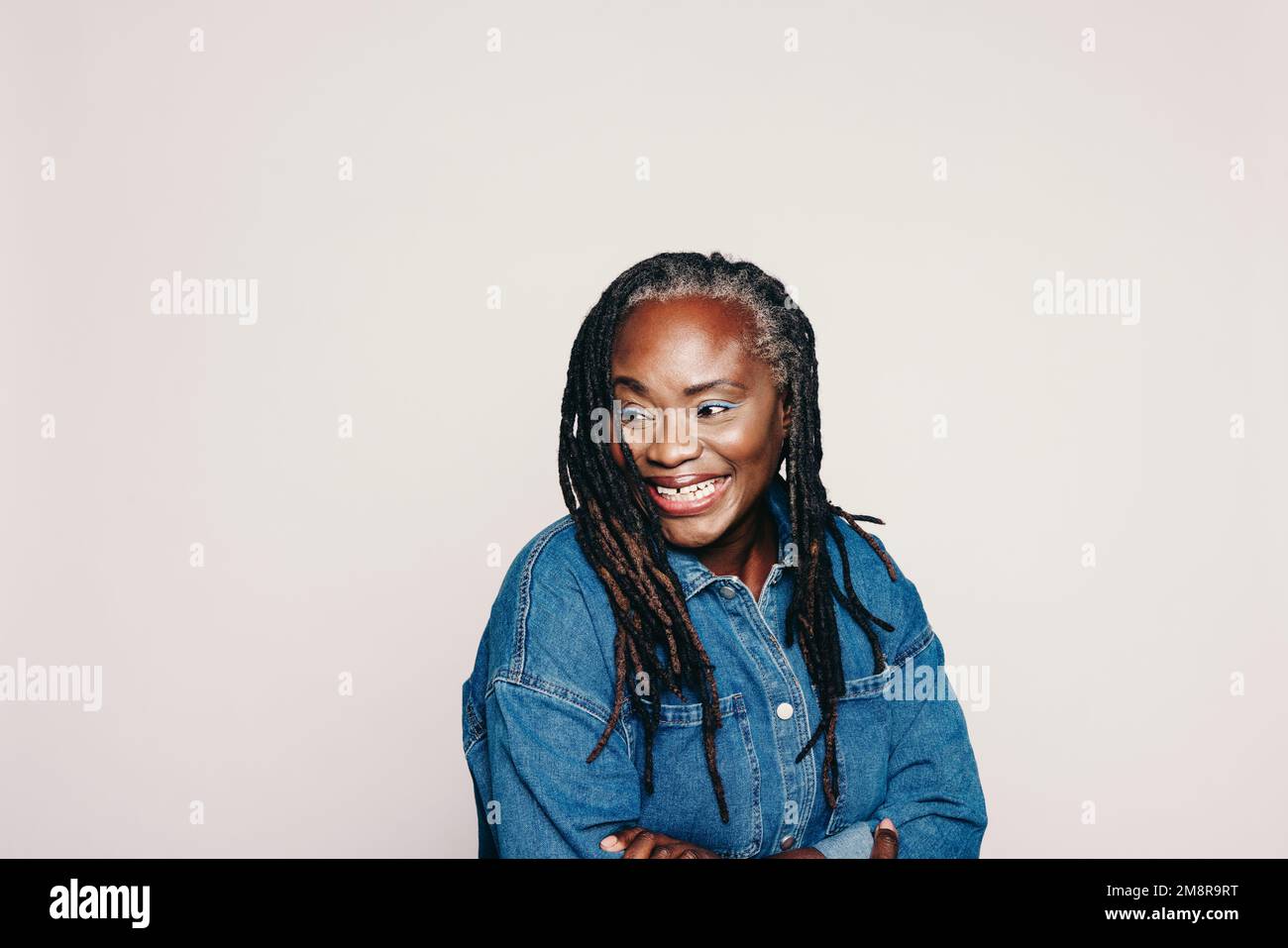 Mature woman with dreadlocks looking away with a happy smile while ...