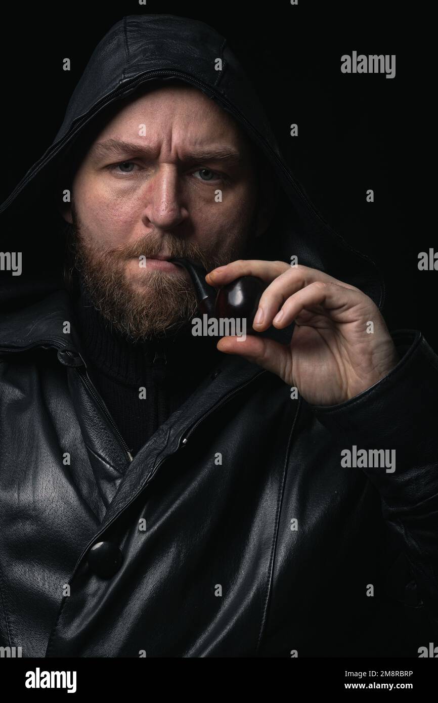 Portrait of a Bearded man in Black Rain Jacket Smoking a Pipe Stock ...