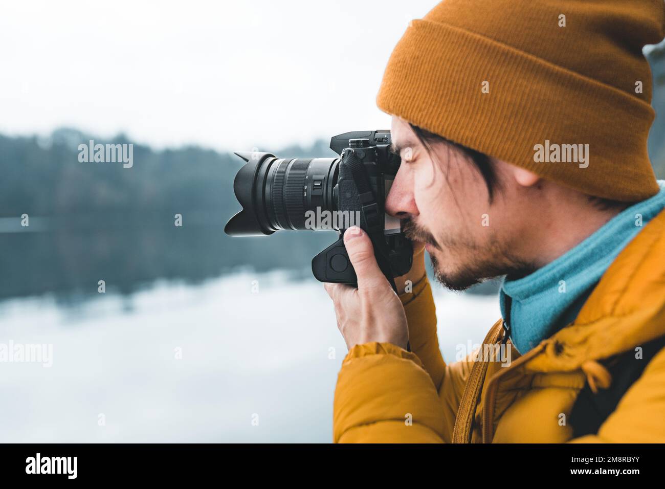 Side view of outdoor photographer taking landscape photos using digital ...
