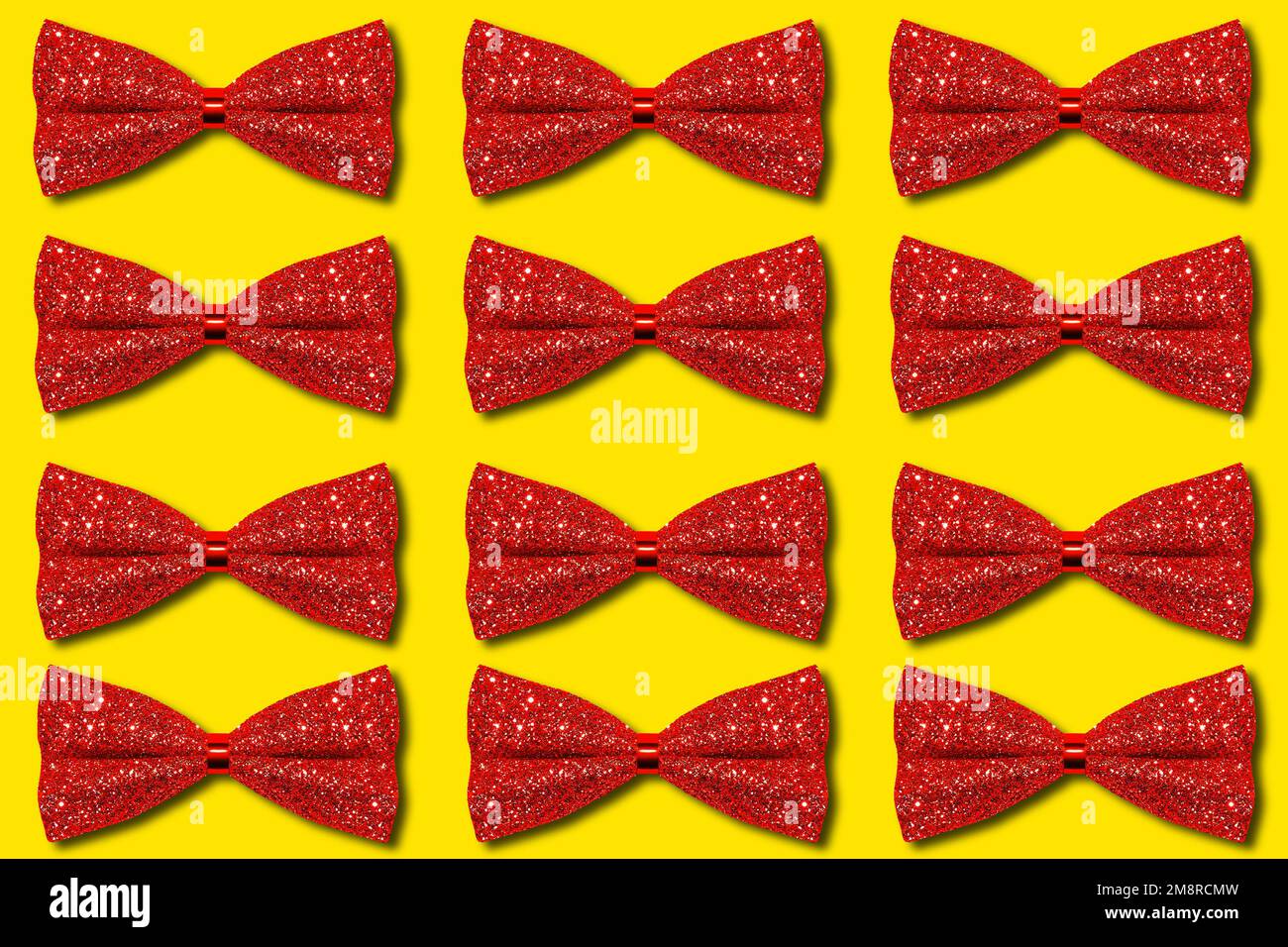 Lots of red shiny bows on a yellow background Stock Photo - Alamy