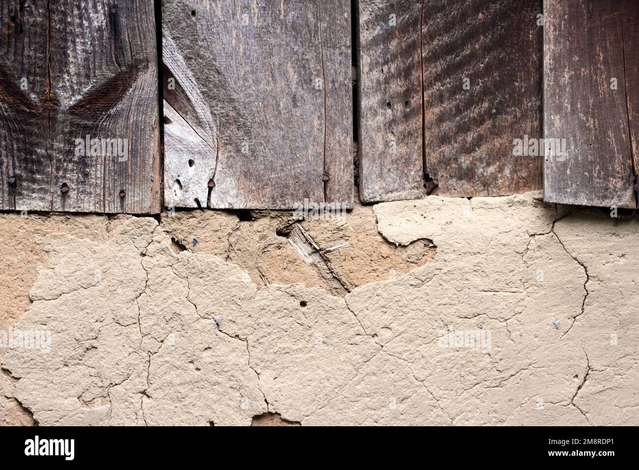 Old cob wall with cracked surface and old wooden boards. Vintage ...