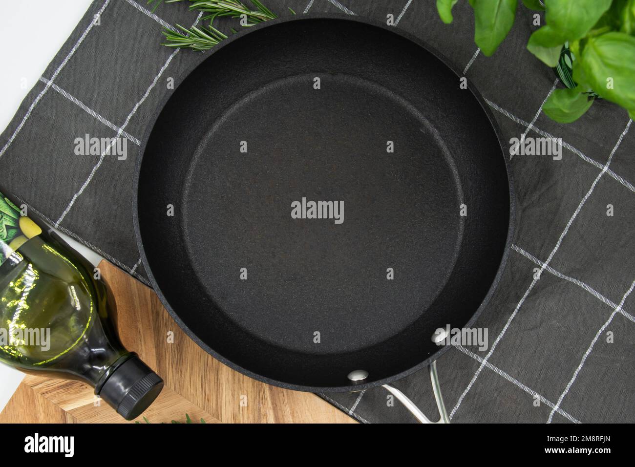 Empty cast iron frying pan on white culinary background, view from ...
