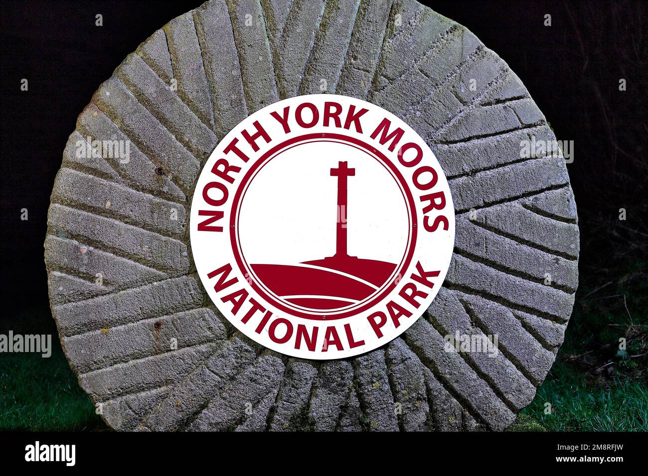 North York Moors National Park sign on a millstone at the foot of ...