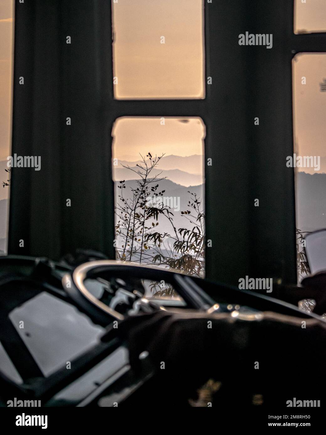 A vertical shot of a window view from a bus with mountains in the ...