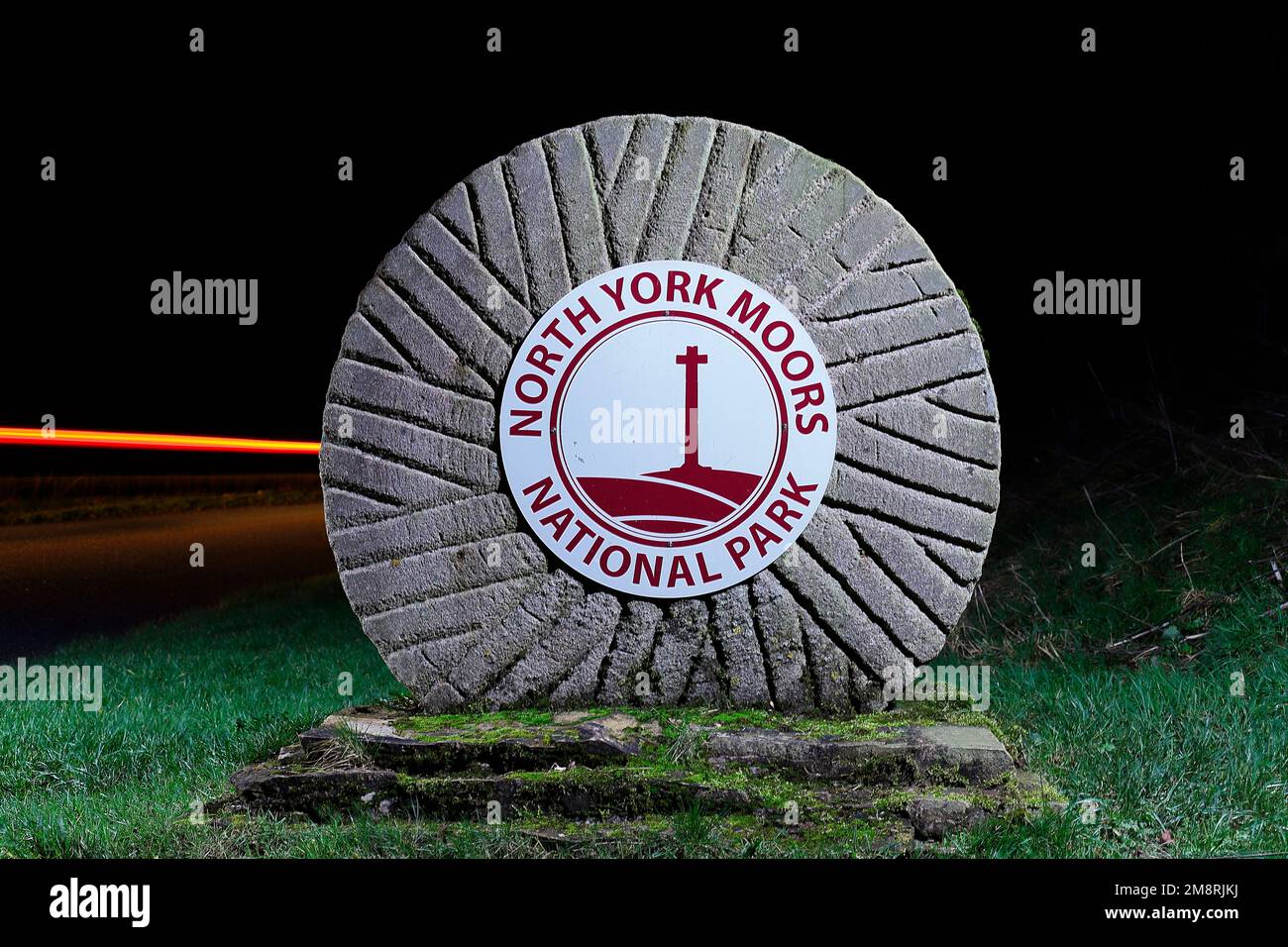 North York Moors National Park sign on a millstone at the foot of ...