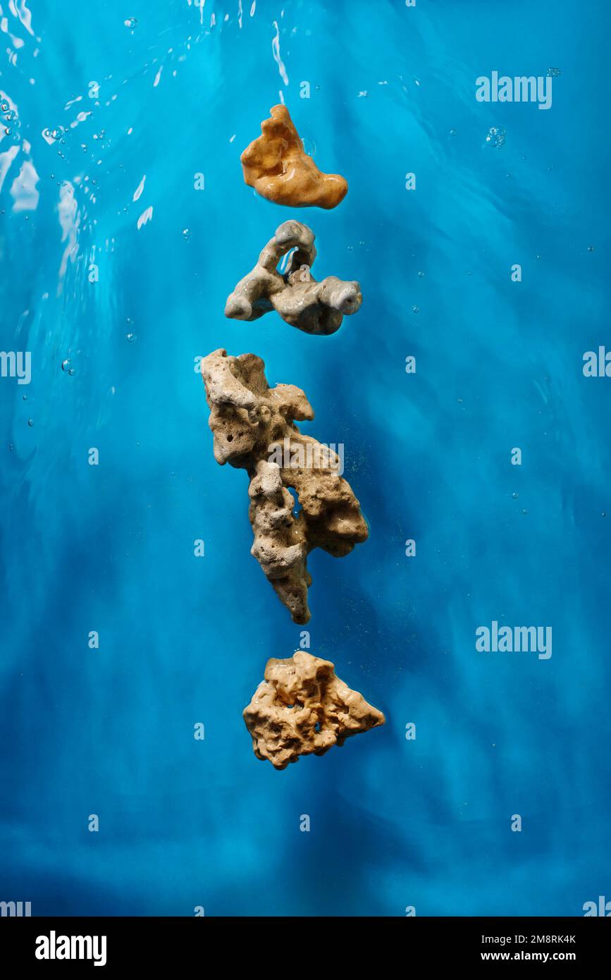 Rock reefs in bright blue ocean water with waves and bubbles Stock ...