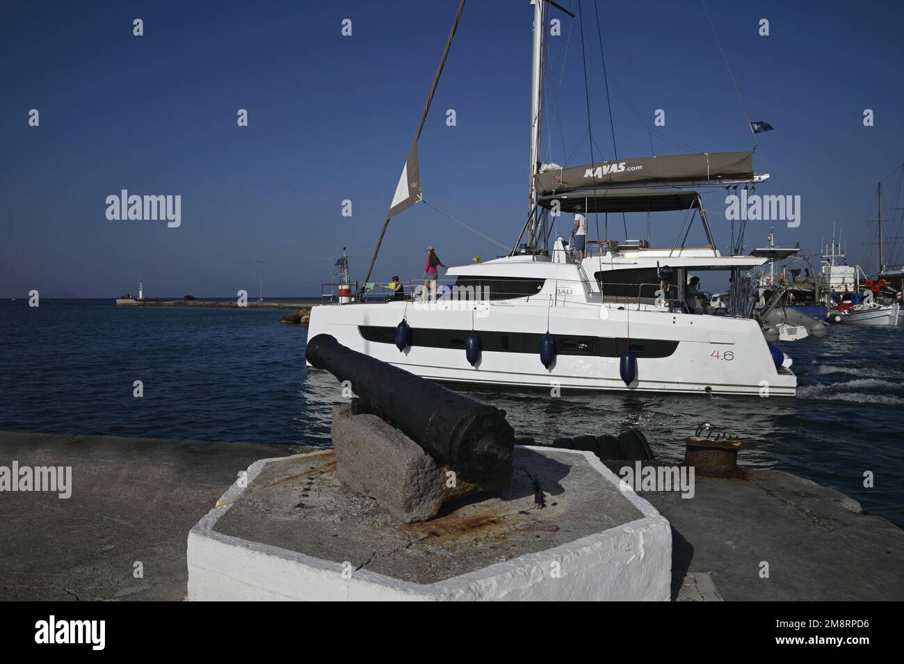 Scenic seascape with a young girl on the stern of a Catamaran sailing ...