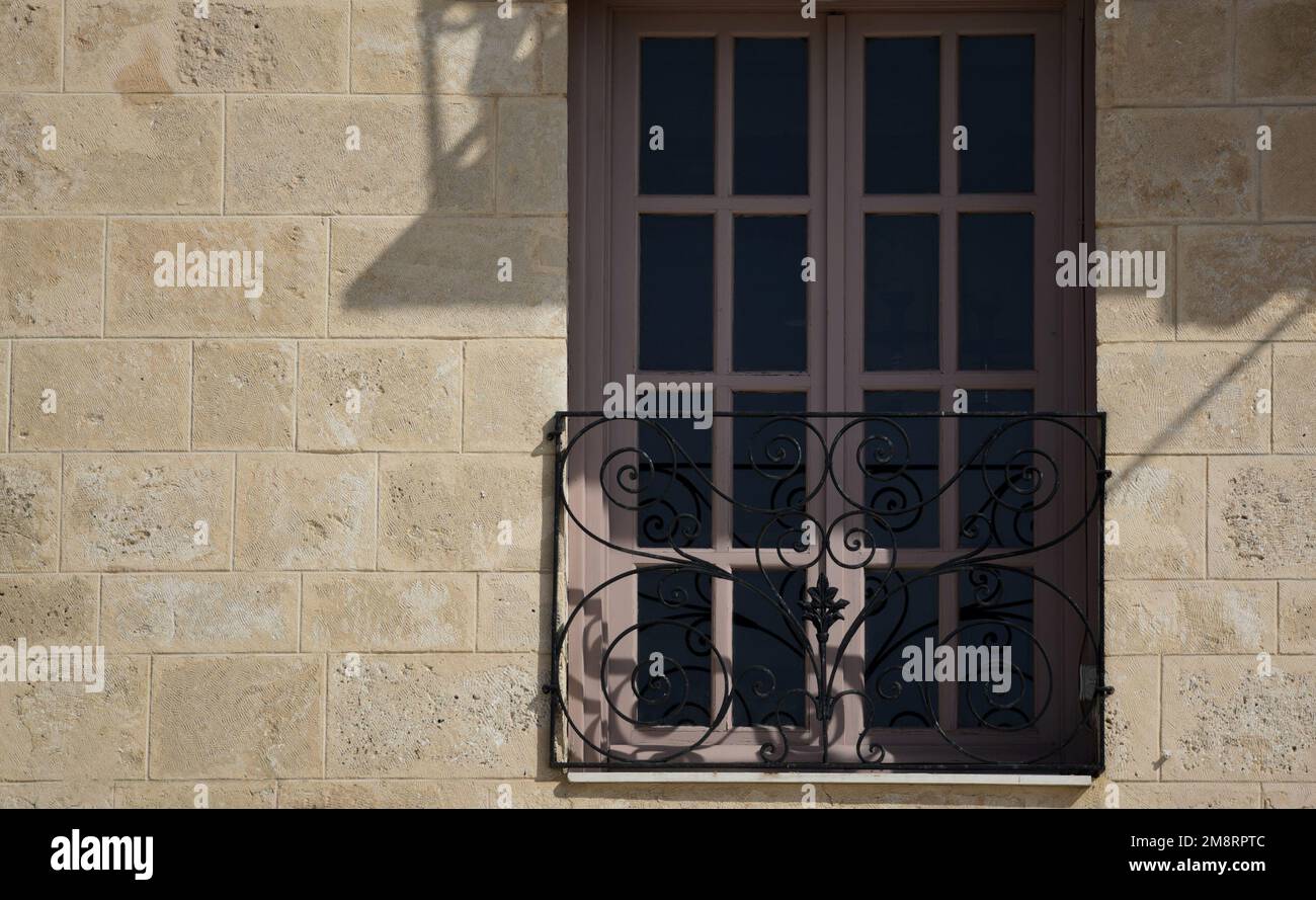 Antique wooden window with handcrafted wrought iron railing on a stone ...