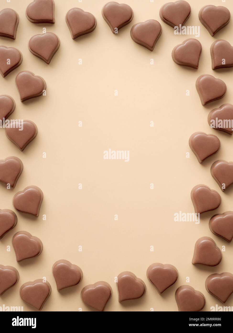 Frame of romantic chocolate confections in heart shapes on pastel ...