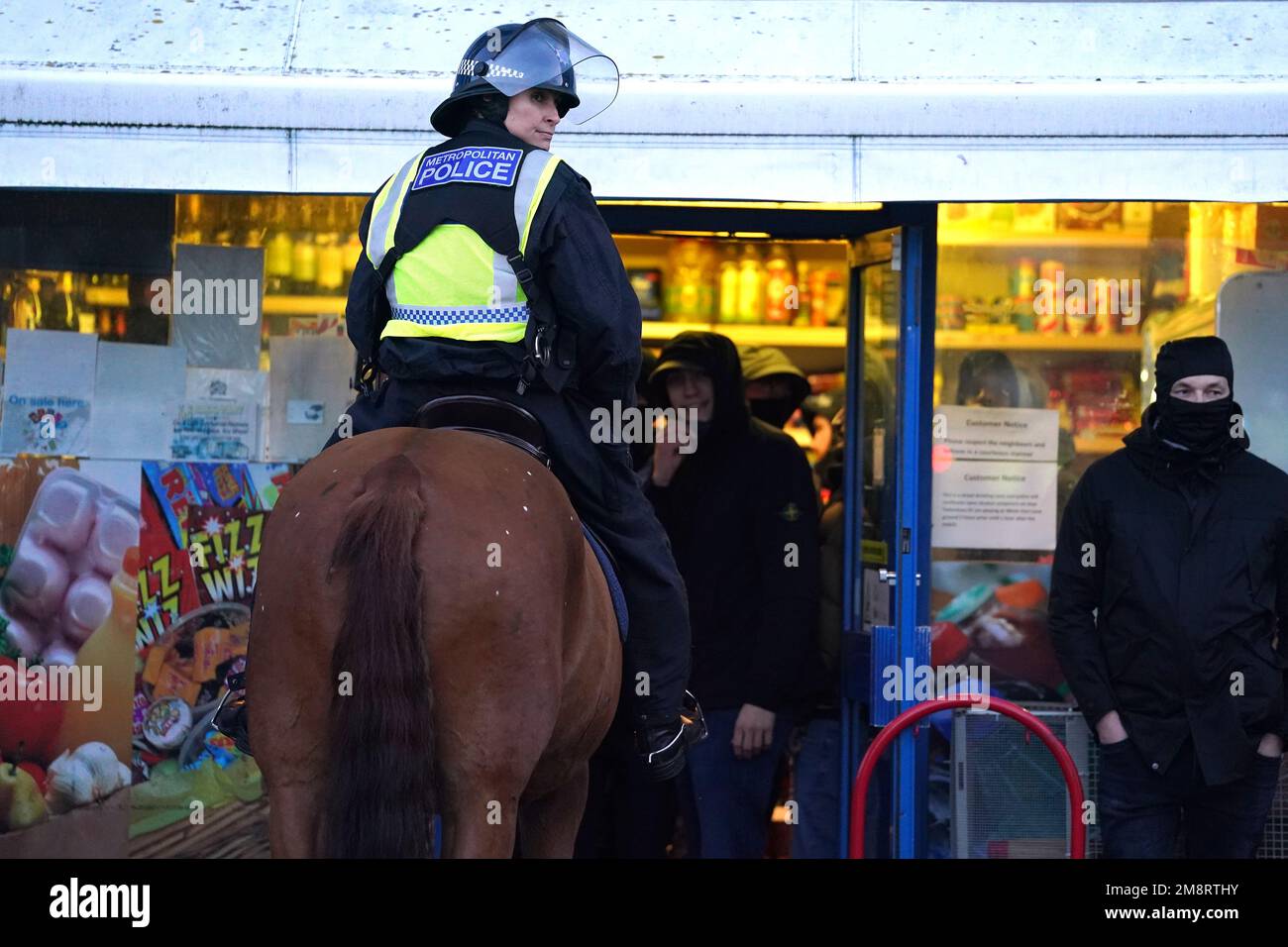 A mounted police officer by a store as fans gather outside before the ...