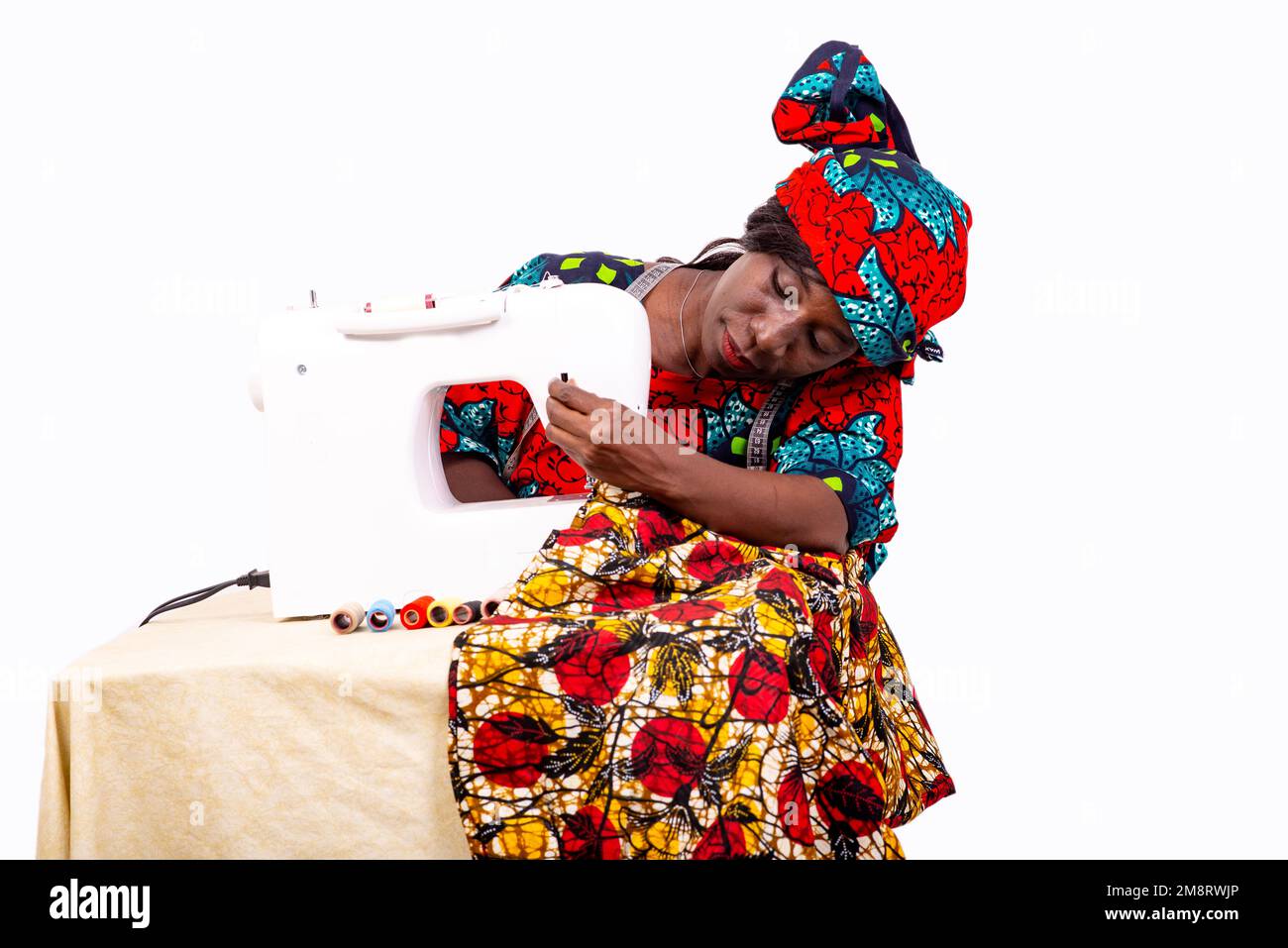 a seamstress in traditional dress sitting behind her sewing machine on ...