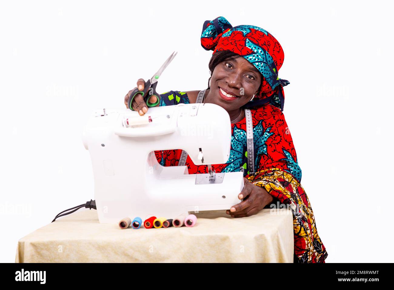 a dressmaker in traditional dress sitting on a white background looking ...