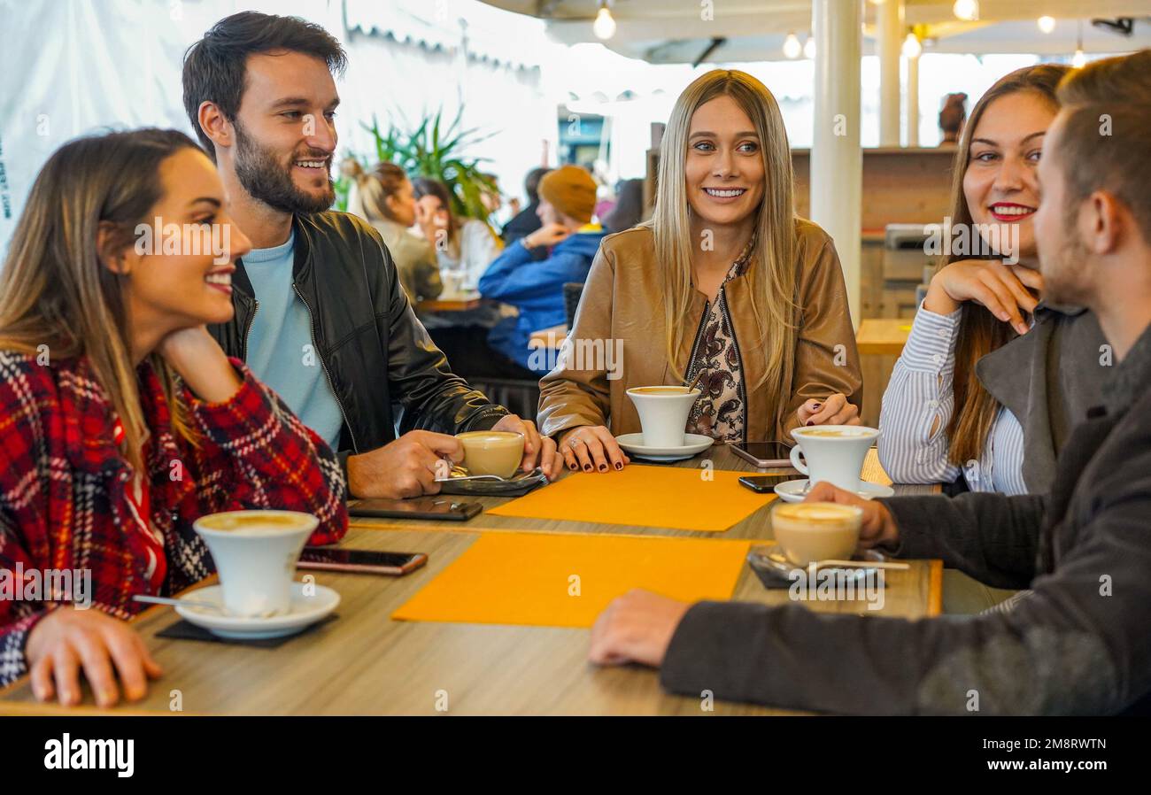 Group of people drinking cappuccino in a bar- Friends hanging out with ...