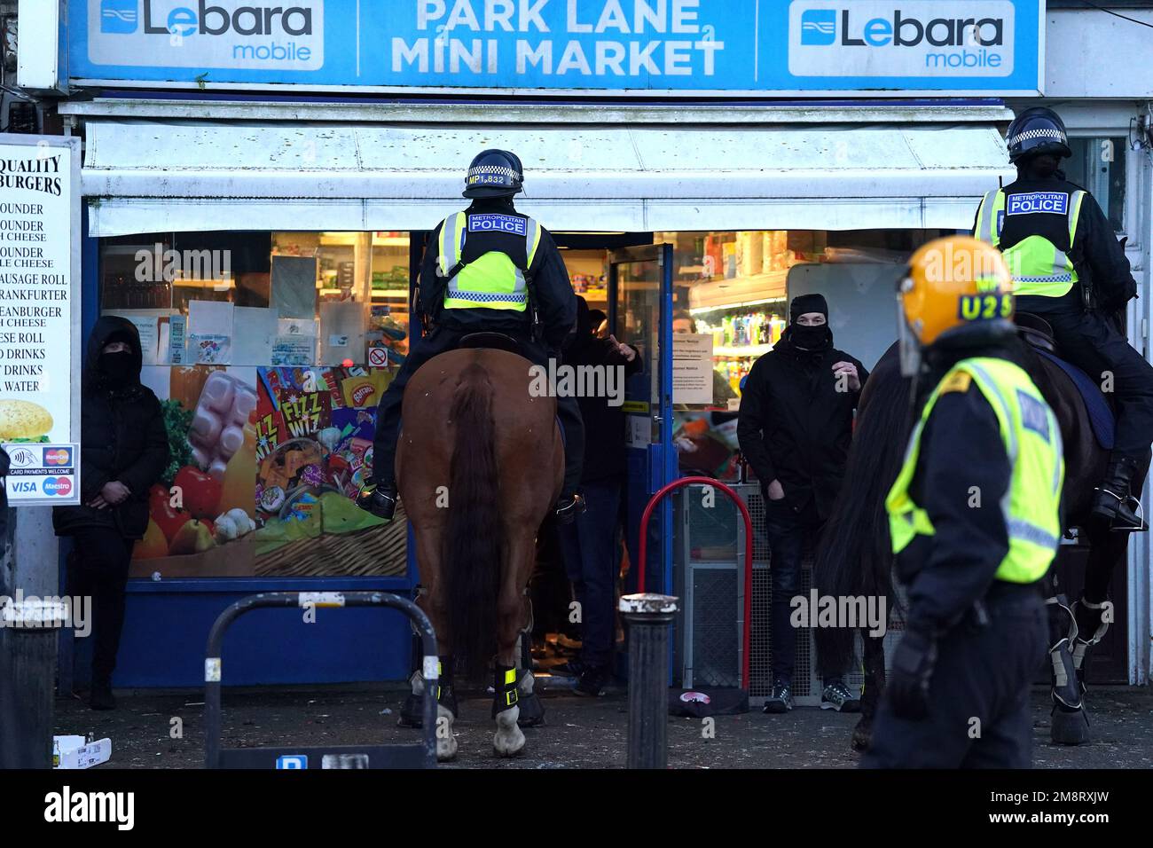 A mounted police officer by a store as fans gather outside before the ...