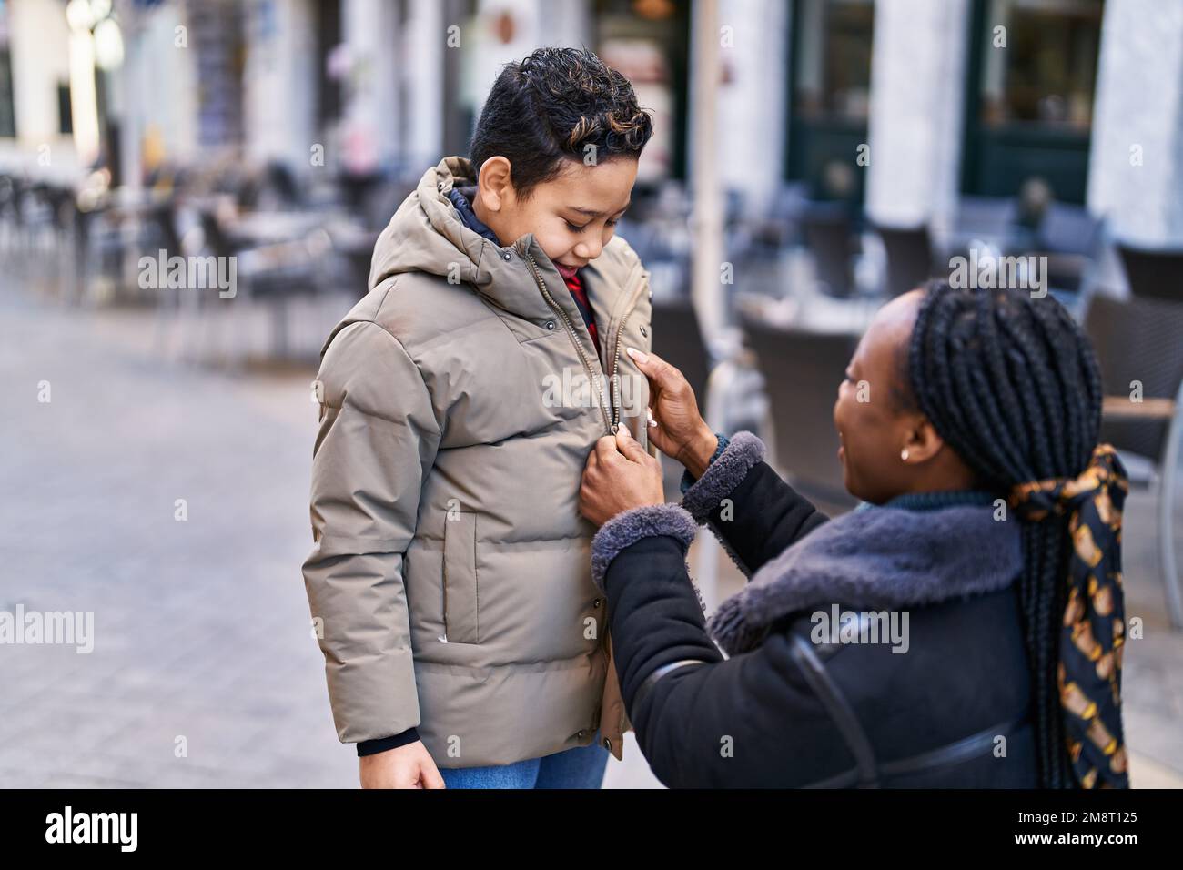 African american mother and son smiling confident closing jacket at ...