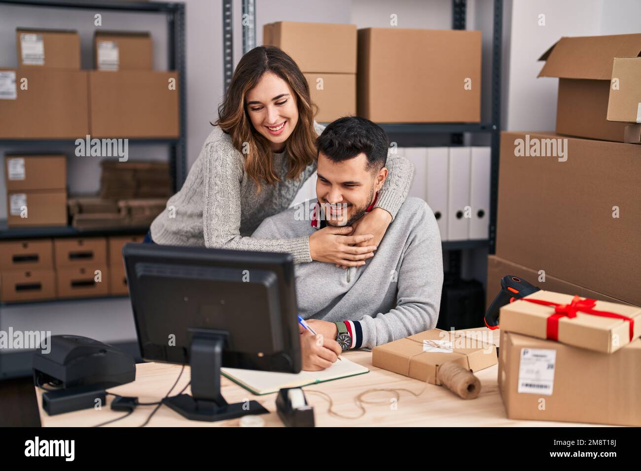 Man and woman ecommerce business workers hugging each other working at ...