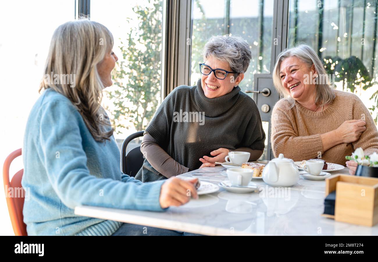 Group of elderly women have breakfast in a cafeteria, three retired ...