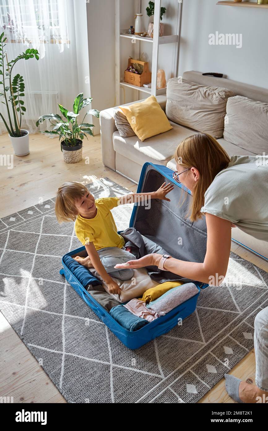 Family mother and child are having fun, the child is hiding in a ...