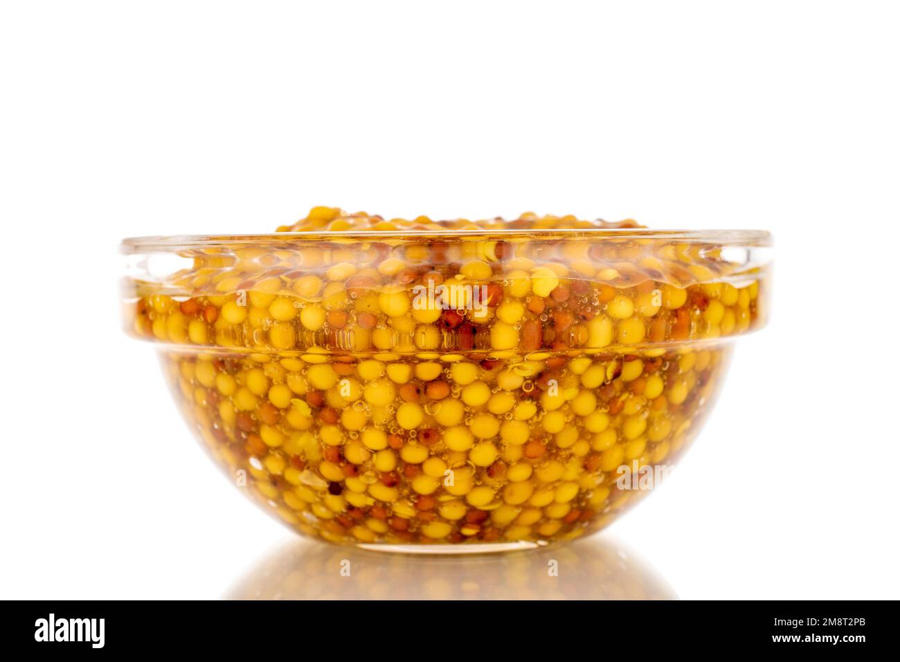 French mustard in a glass plate, macro, isolated on white background ...