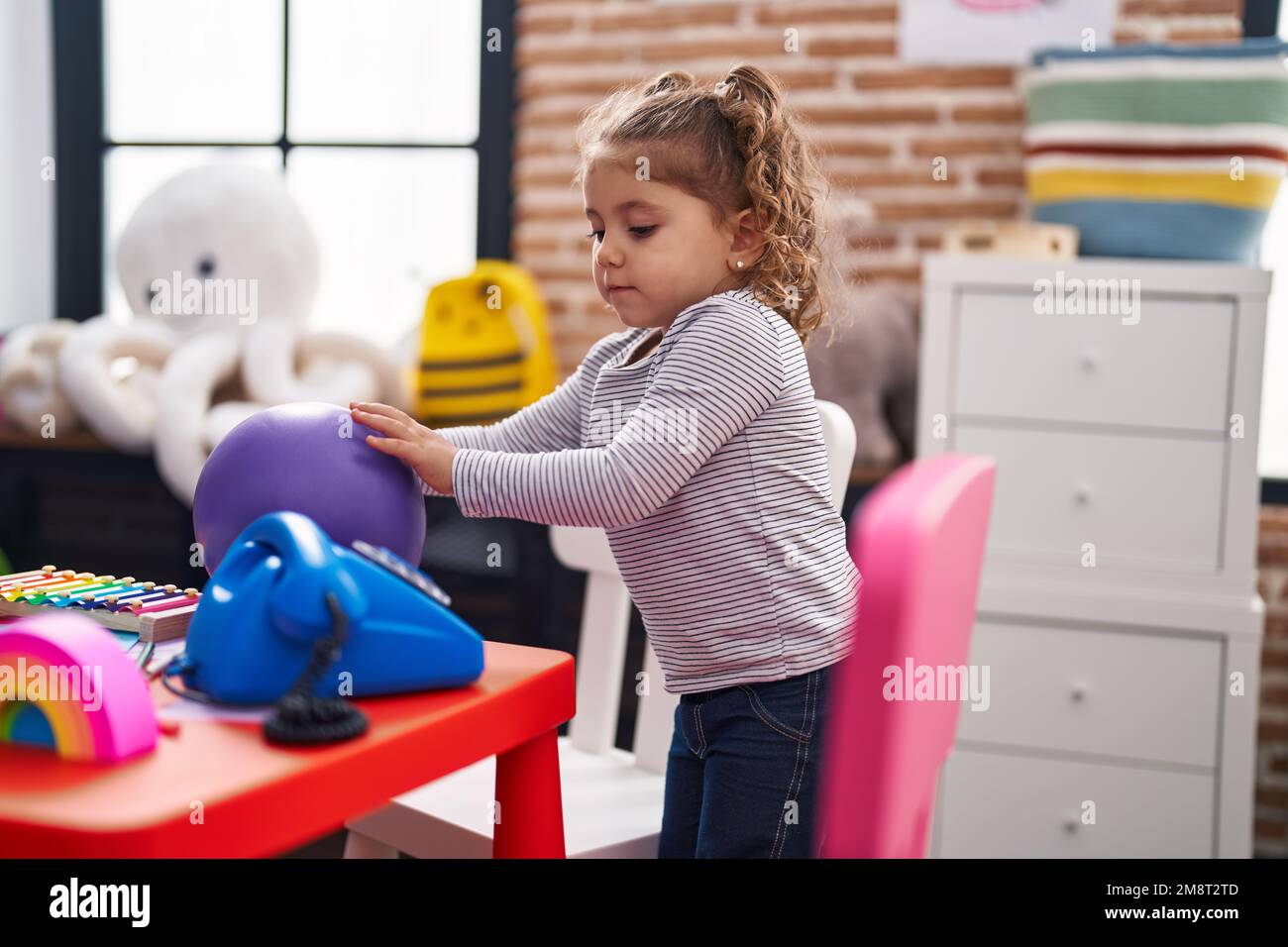 Adorable caucasian girl standing with relaxed expression at ...