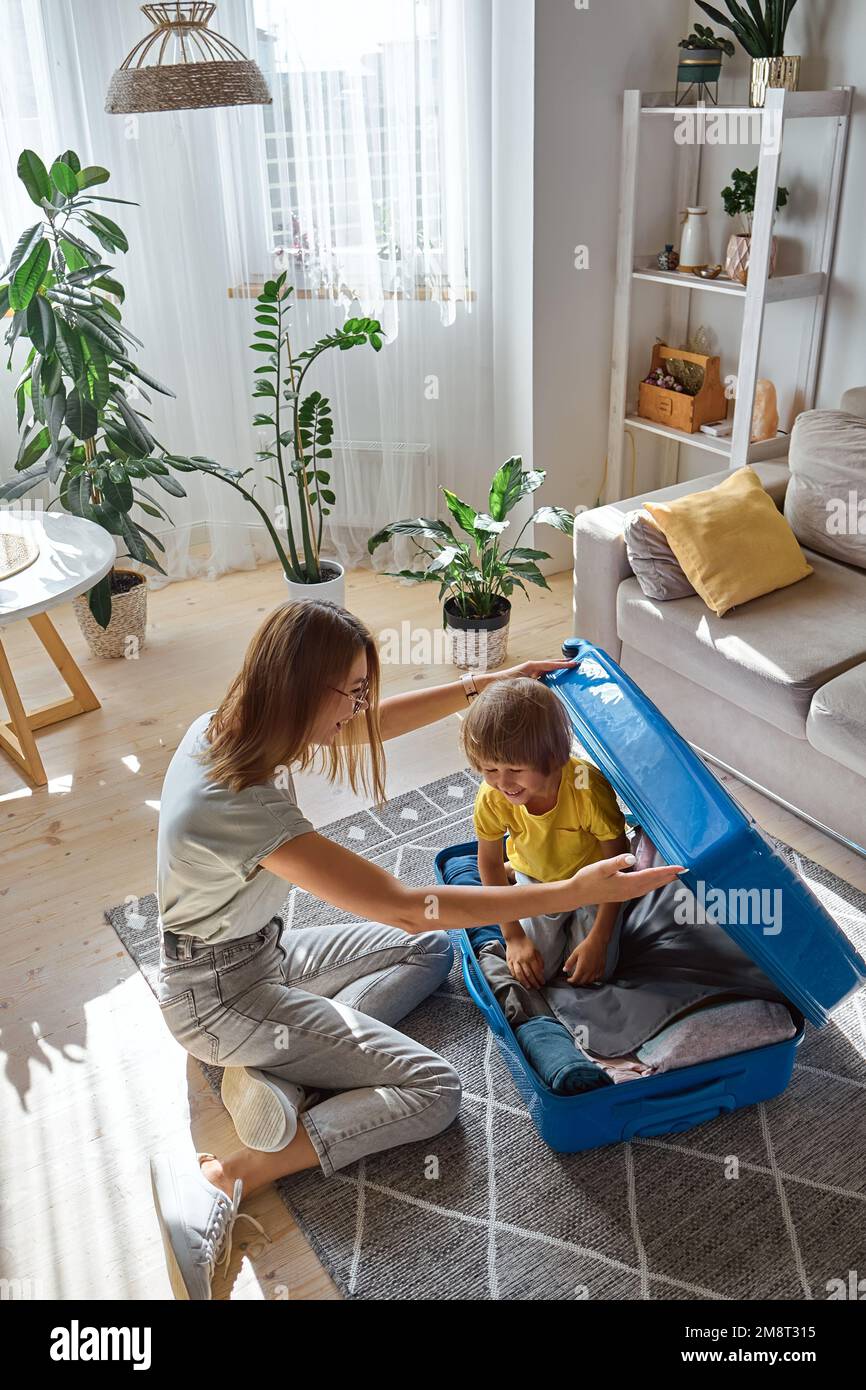 Family mother and child are having fun, the child is hiding in a ...