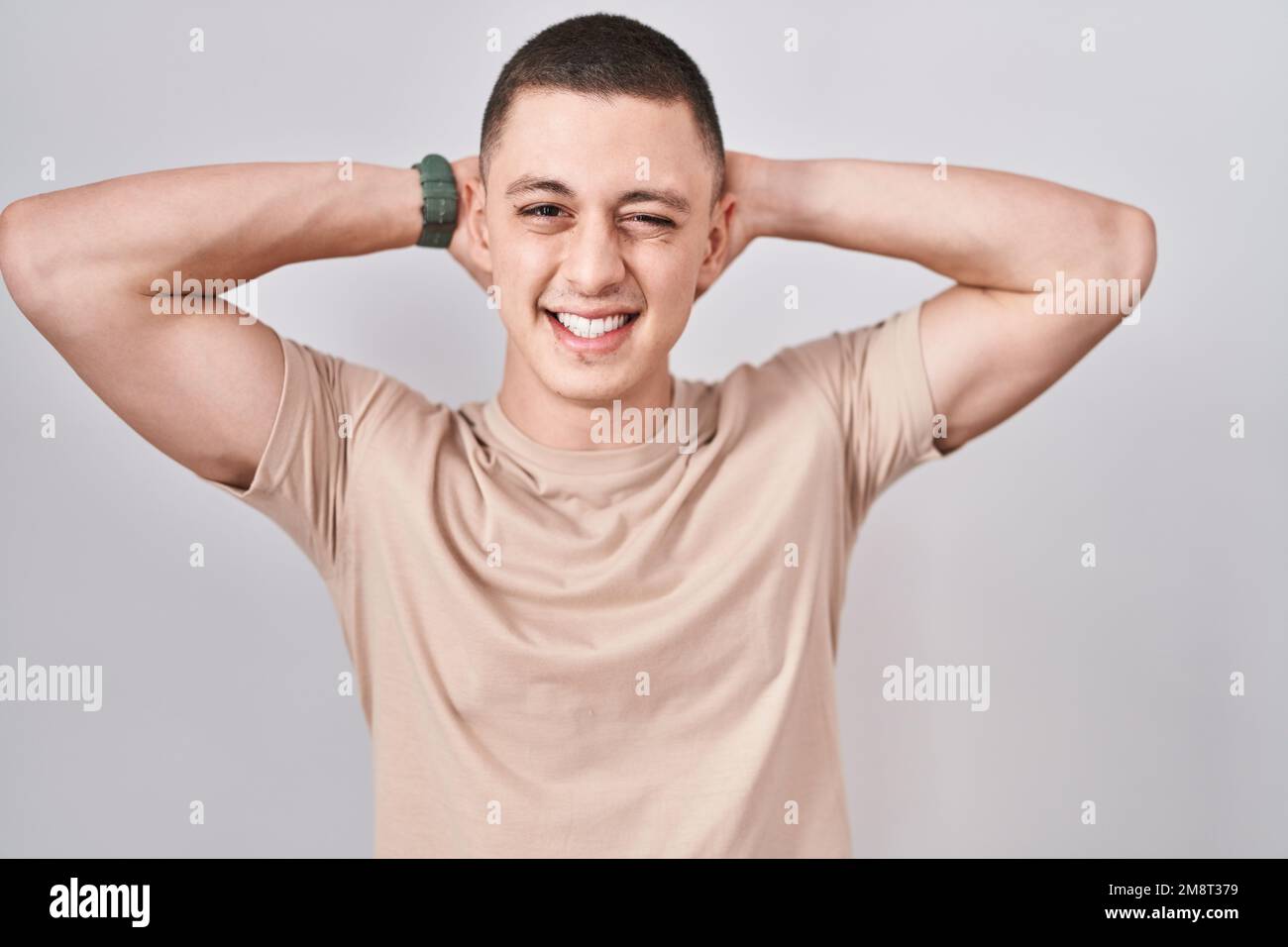 Young man standing over isolated background relaxing and stretching ...