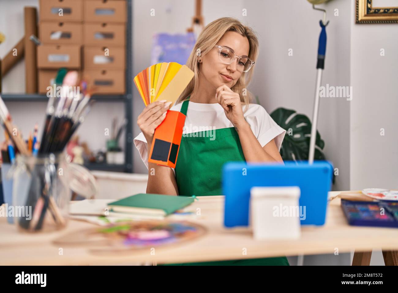 Young caucasian woman doing video call showing color palette serious ...