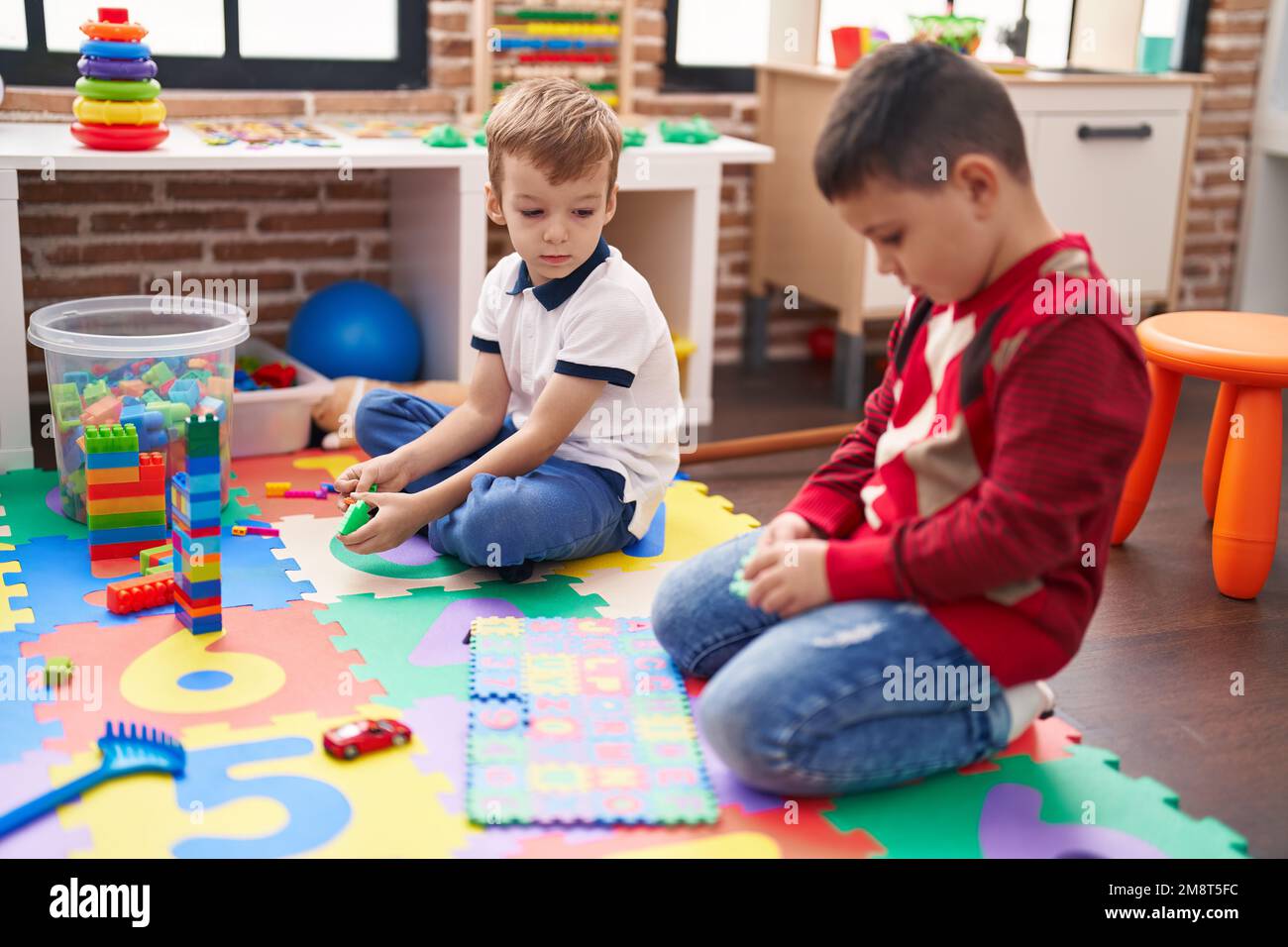 Two kids playing with construction blocks and maths puzzle game sitting ...