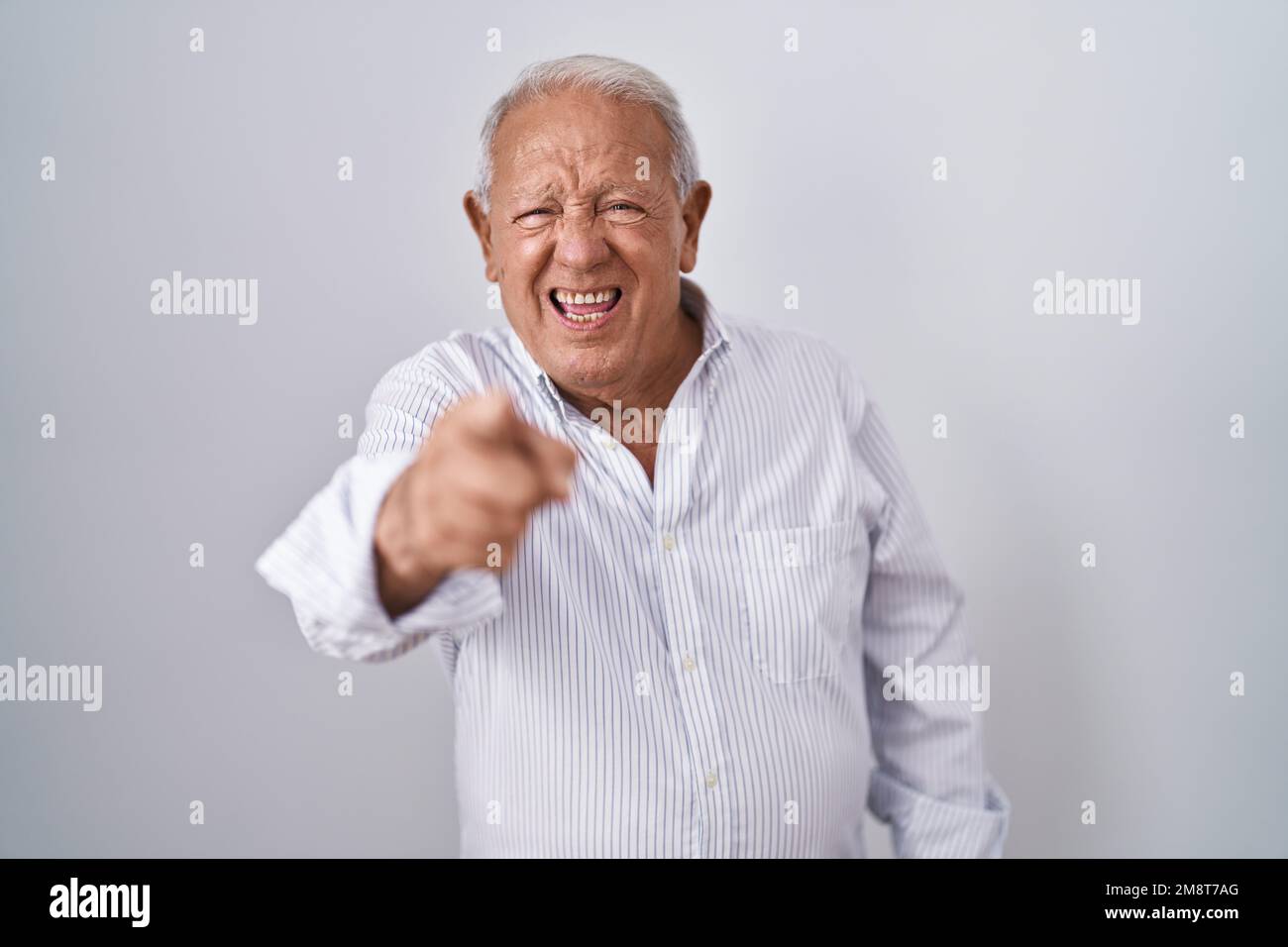 Senior man with grey hair standing over isolated background pointing ...