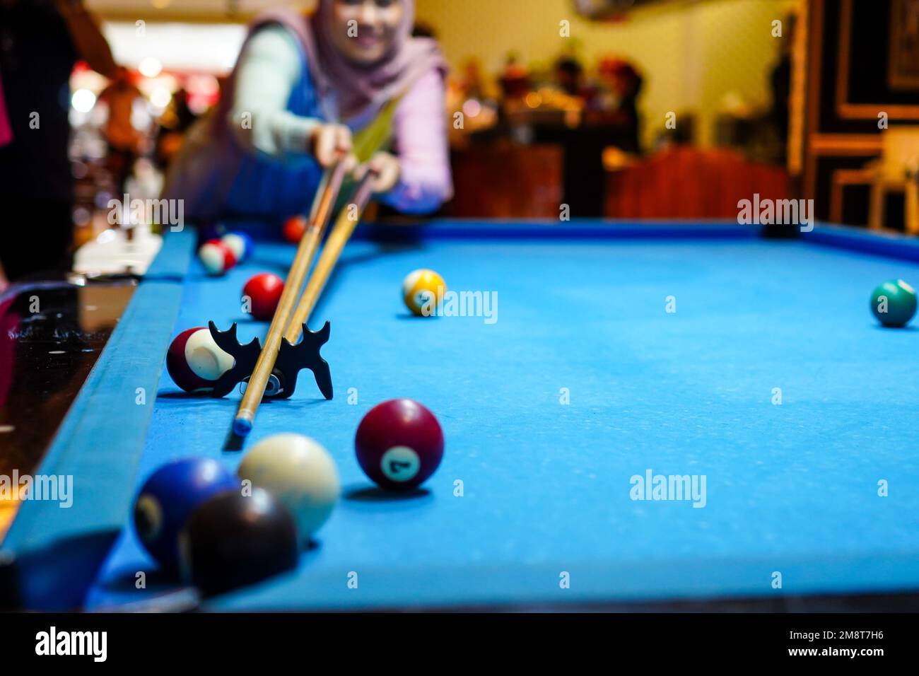 Women in hijabs play billiards with the help of a bridge Stock Photo ...