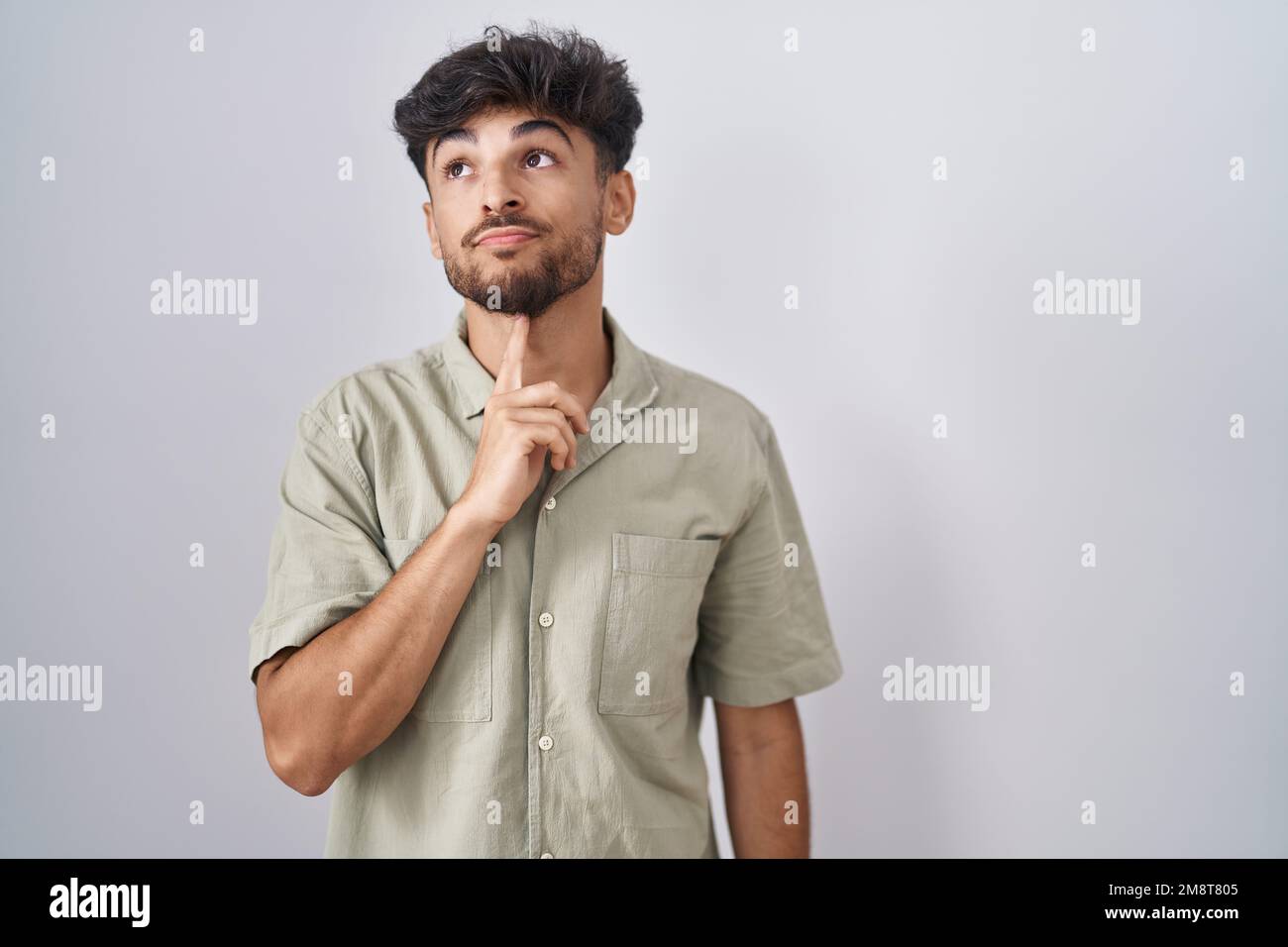 Arab man with beard standing over white background thinking ...
