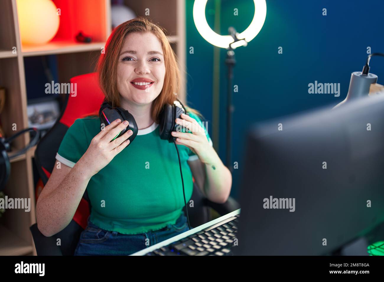 Young redhead woman streamer smiling confident sitting on table at ...