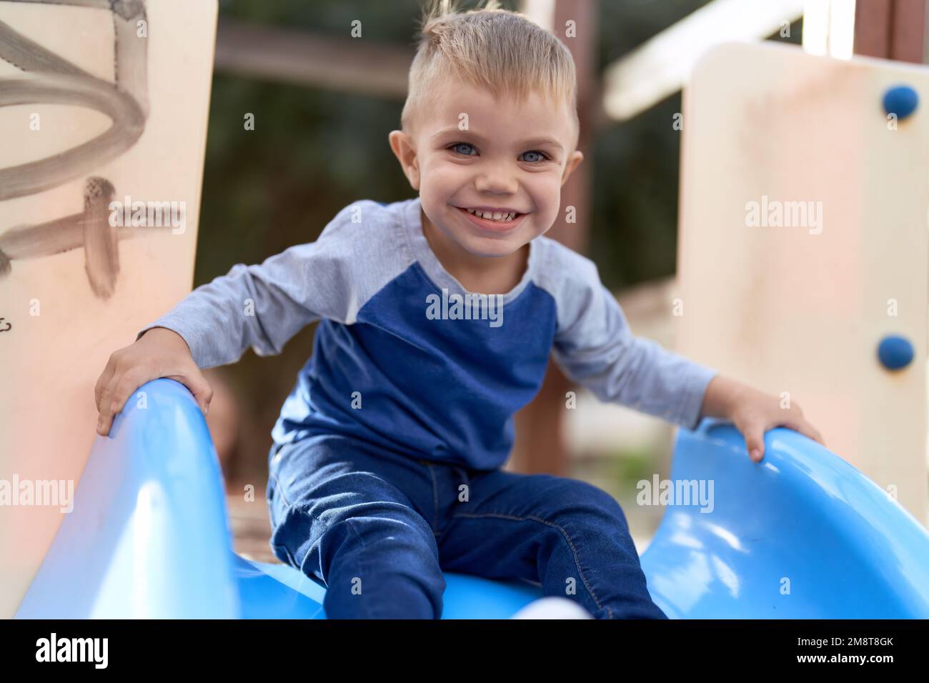 Adorable toddler smiling confident playing on slide at park playground Stock Photo - Alamy