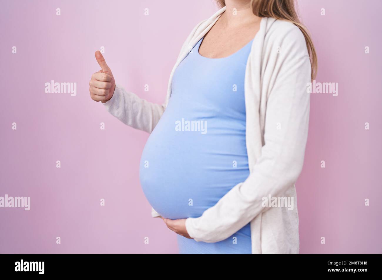 Young pregnant woman expecting a baby, touching pregnant belly smiling ...