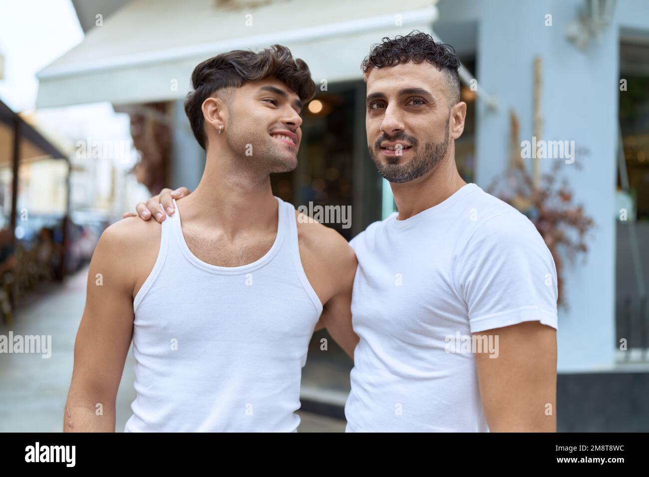 Two hispanic men couple smiling confident hugging each other at coffee ...