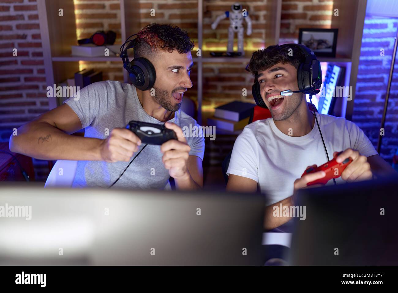 Two hispanic men streamers playing video game using joystick at gaming ...