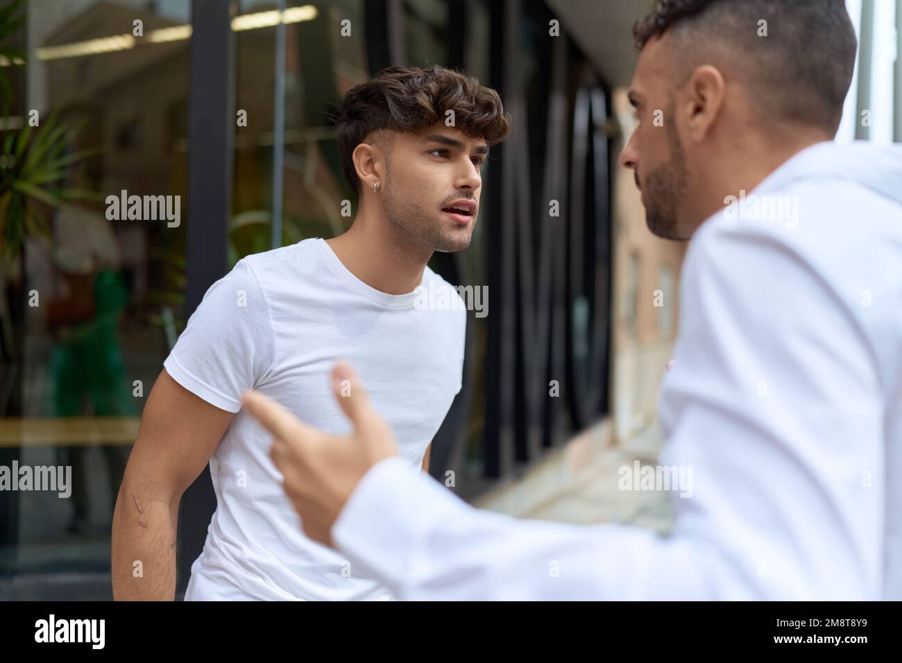 Two hispanic men couple arguing at street Stock Photo - Alamy