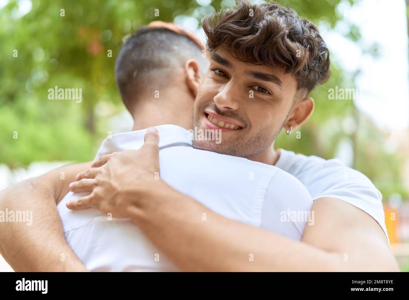 Two hispanic men couple smiling confident hugging each other at park ...