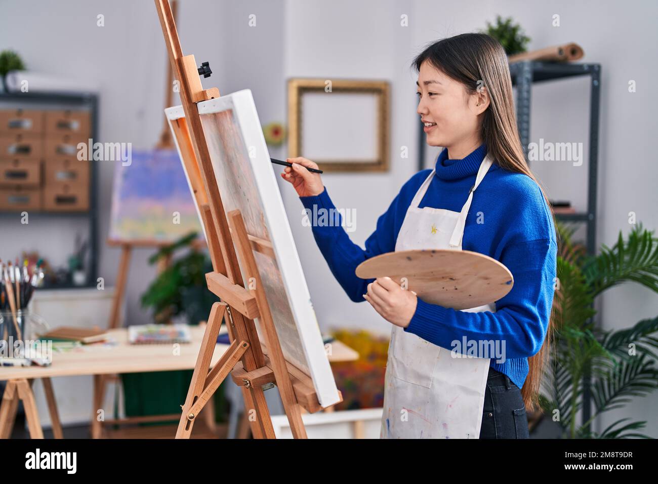 Chinese woman artist smiling confident drawing at art studio Stock Photo - Alamy