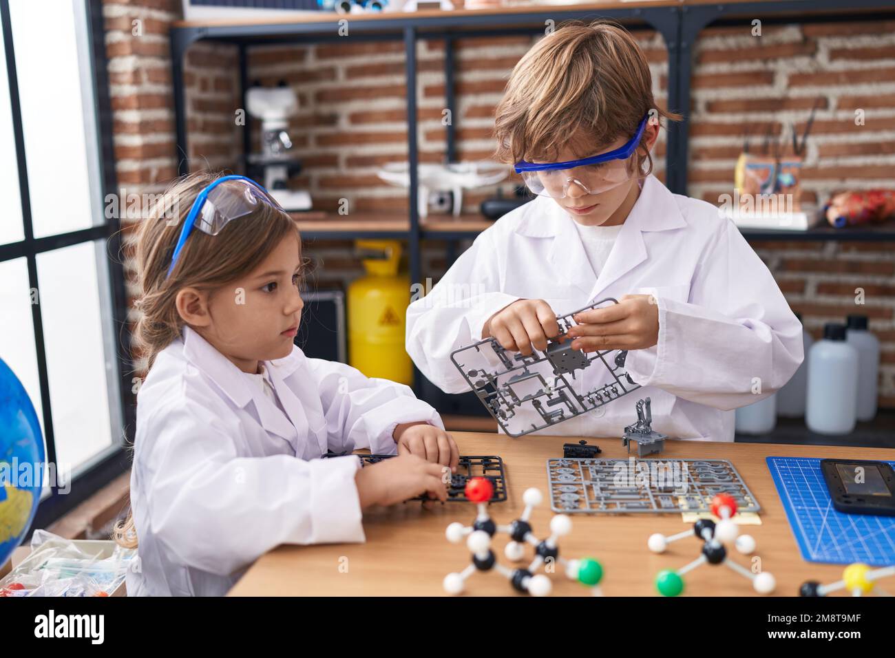 Brother and sister students doing experiment at laboratory classroom ...