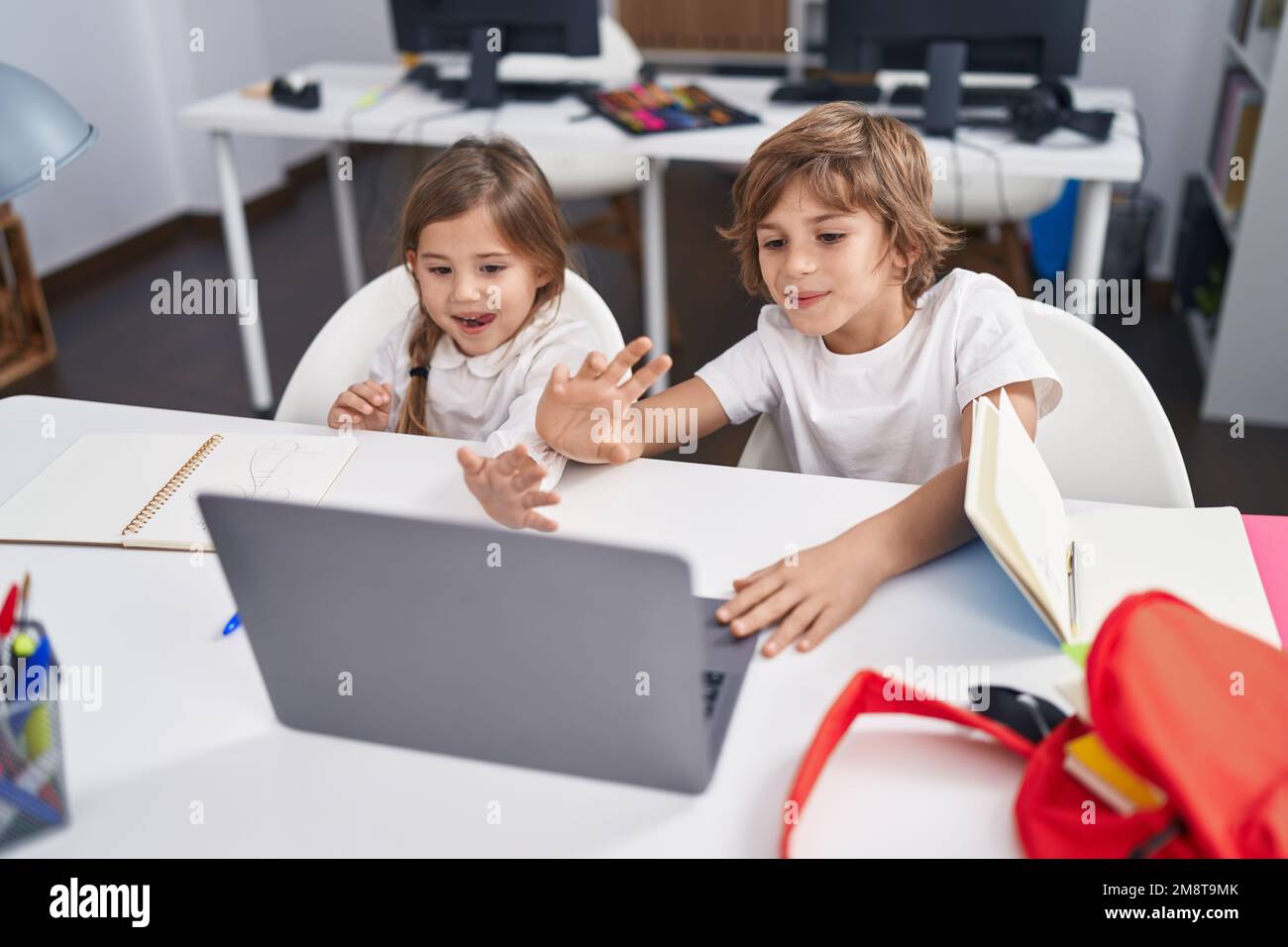 Brother and sister students having long distance education at classroom ...