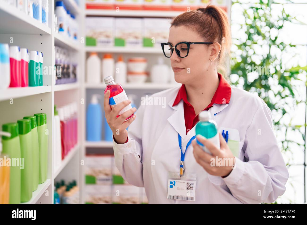 Young beautiful plus size woman pharmacist holding medication bottles ...