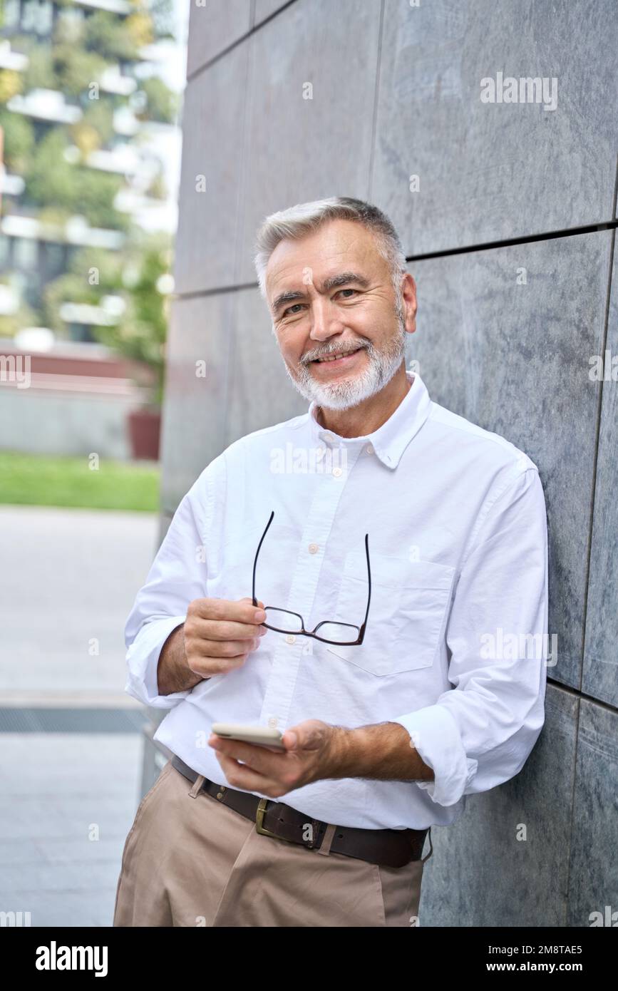 Happy old professional business man holding smartphone using cell phone ...