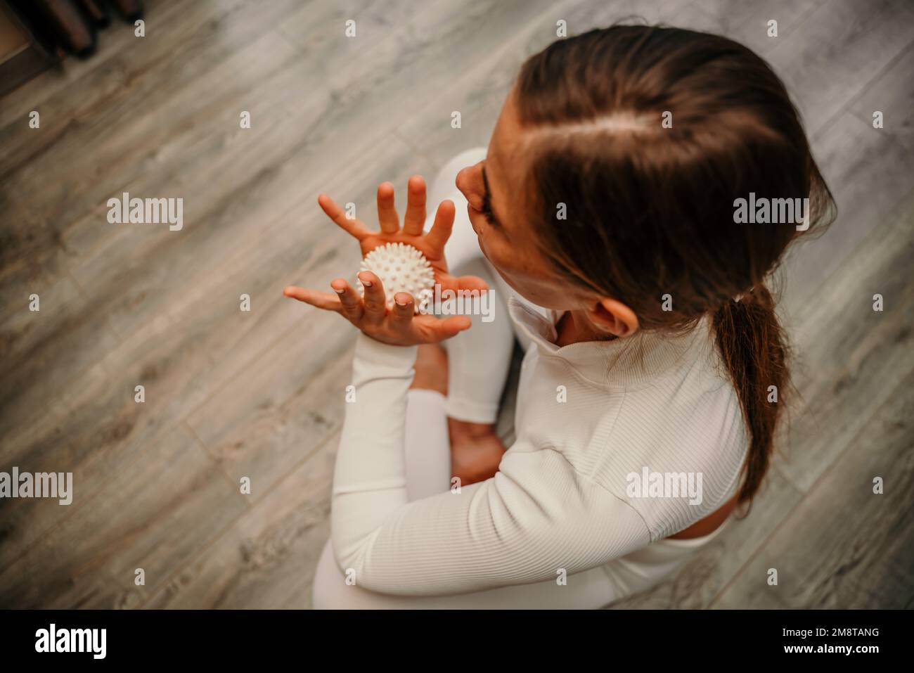 Athletic slim caucasian woman doing thigh self-massage with a massage ...