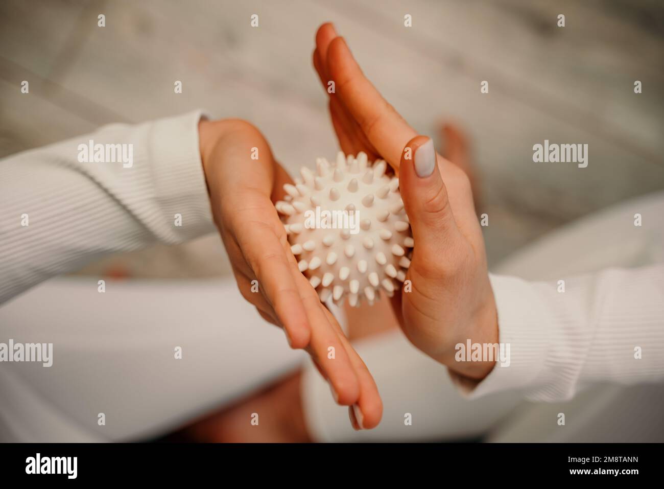 Athletic slim caucasian woman doing thigh self-massage with a massage ...