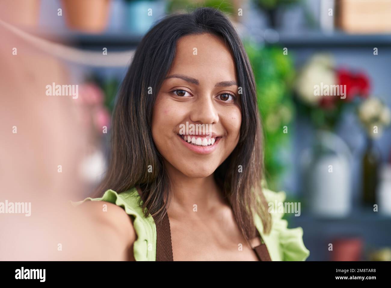 Young hispanic woman florist smiling confident make selfie by camera at ...