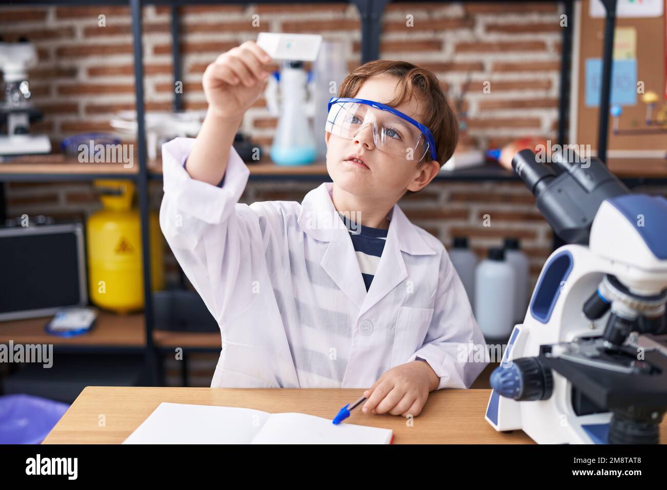 Adorable hispanic boy student smiling confident looking sample at ...
