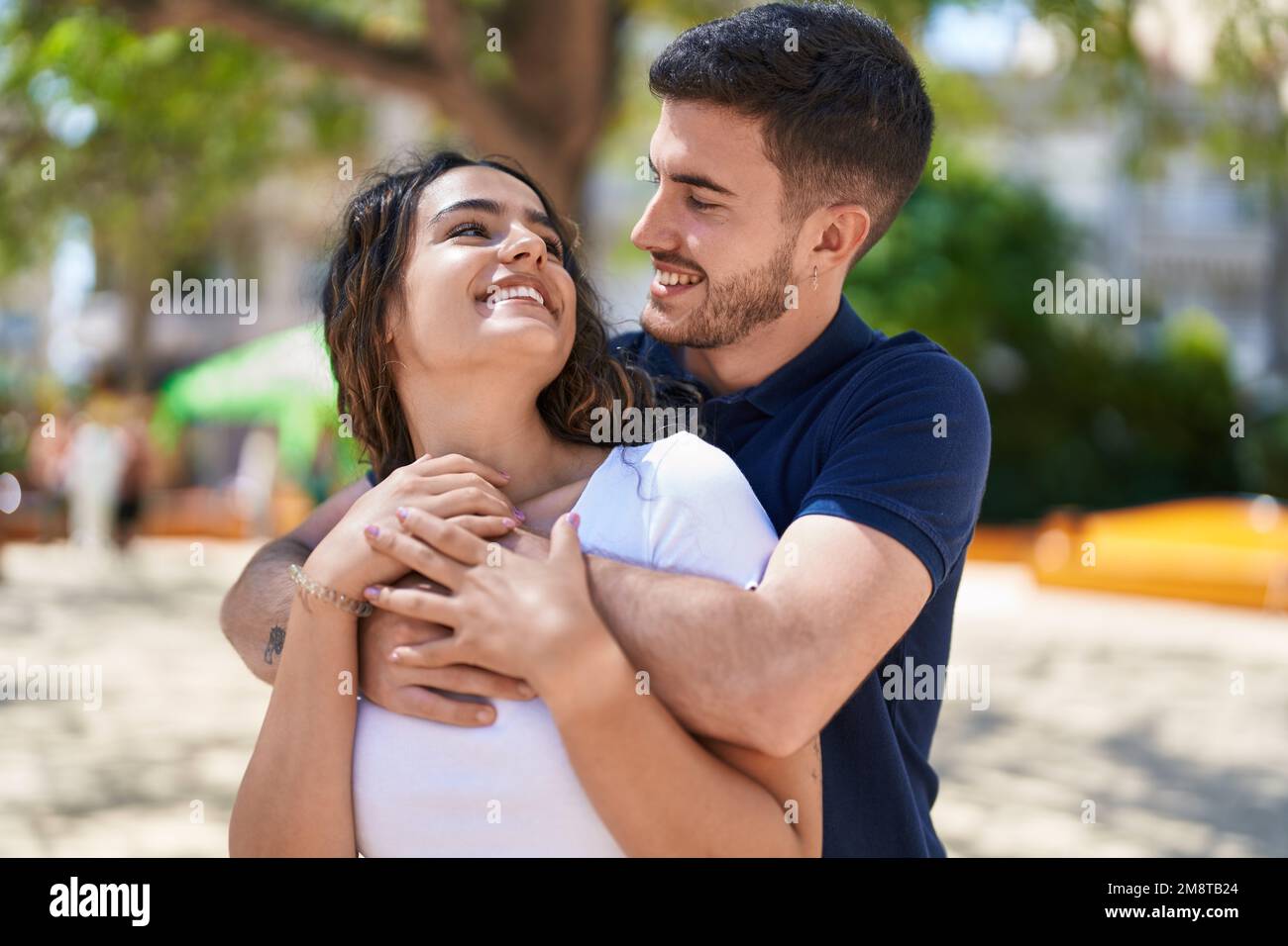 Young hispanic couple smiling confident hugging each other at park ...