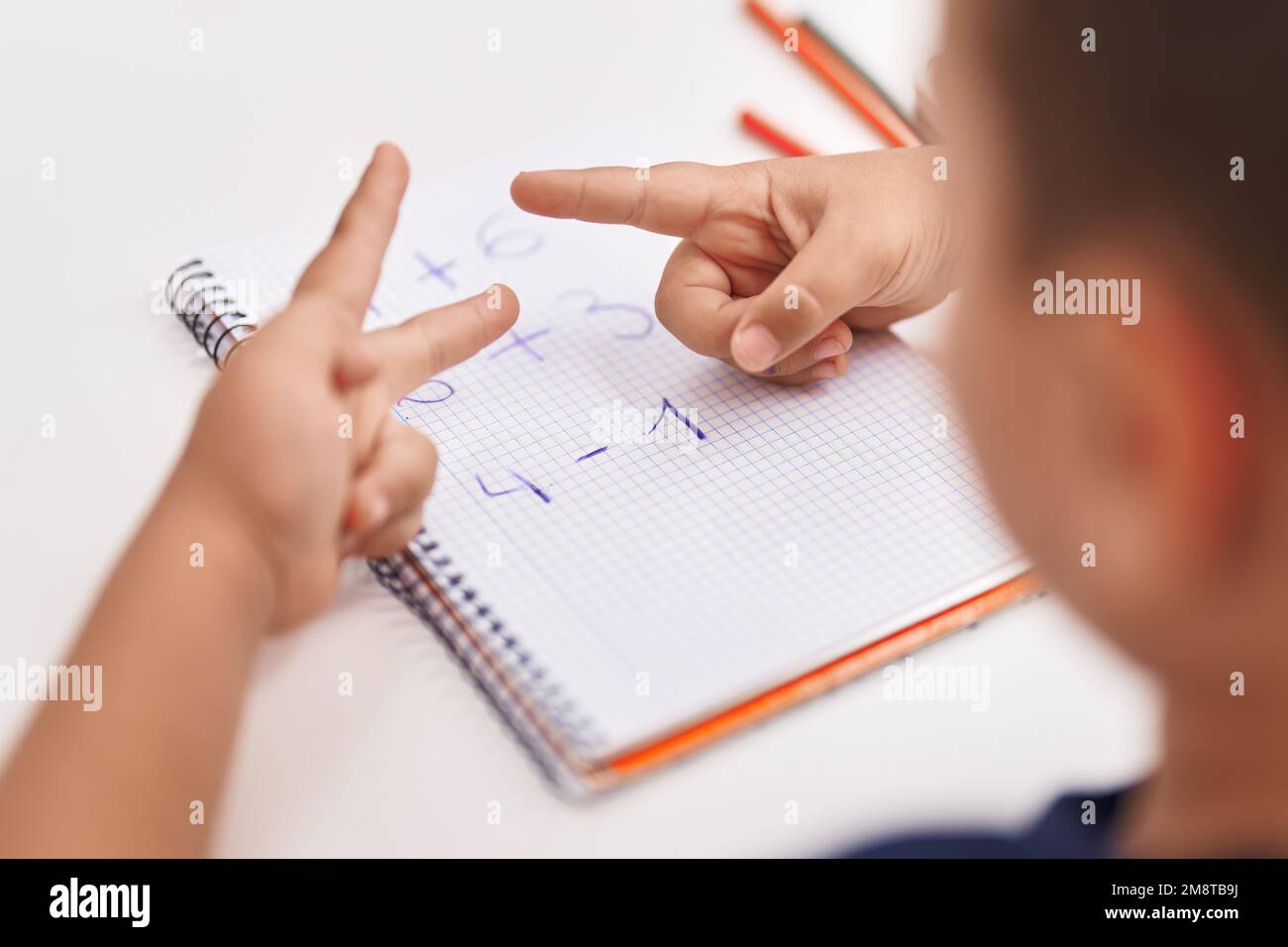 Adorable hispanic toddler doing mathematics exercise counting with ...