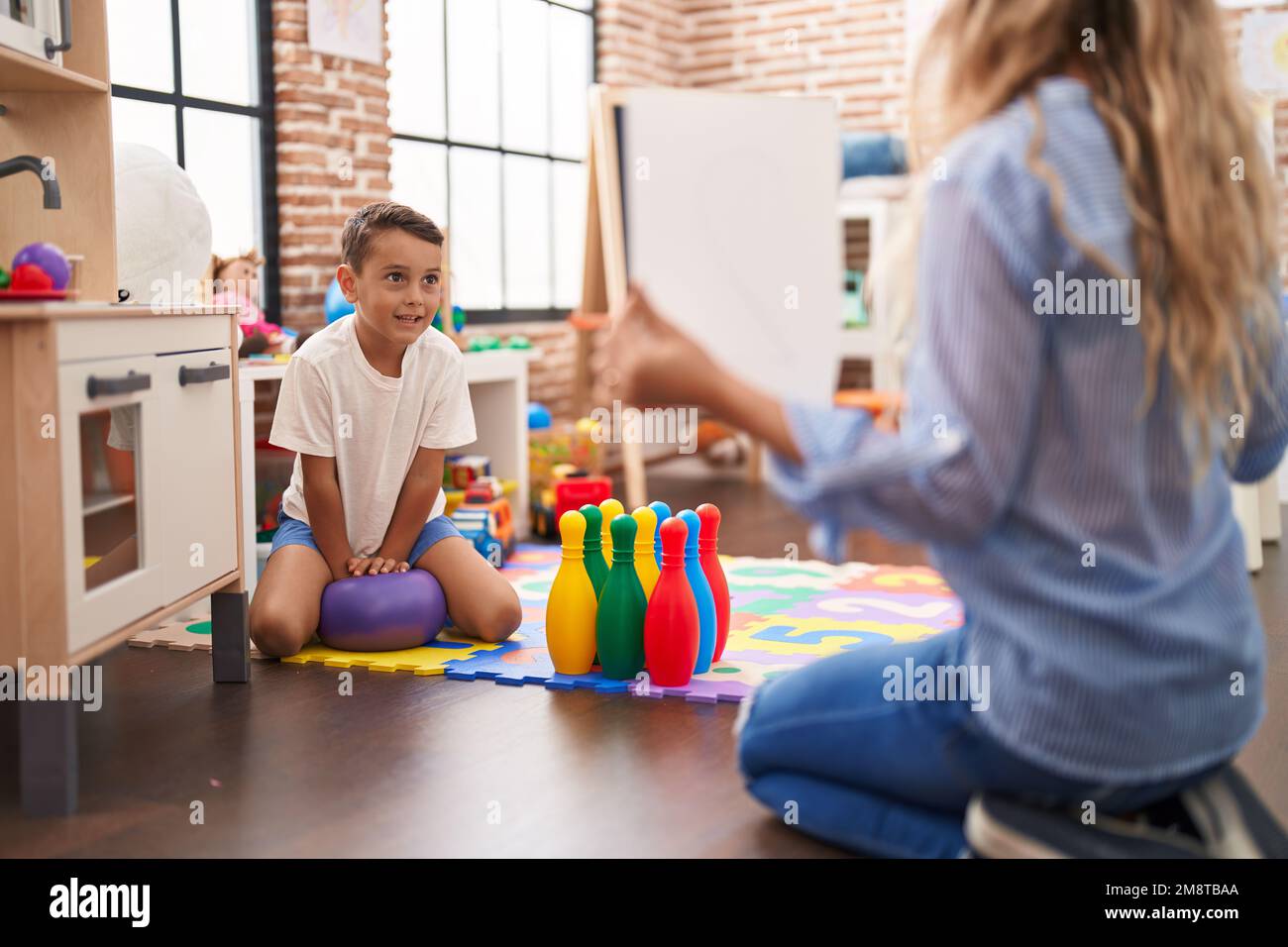 Adorable hispanic toddler sitting on floor having lesson at ...